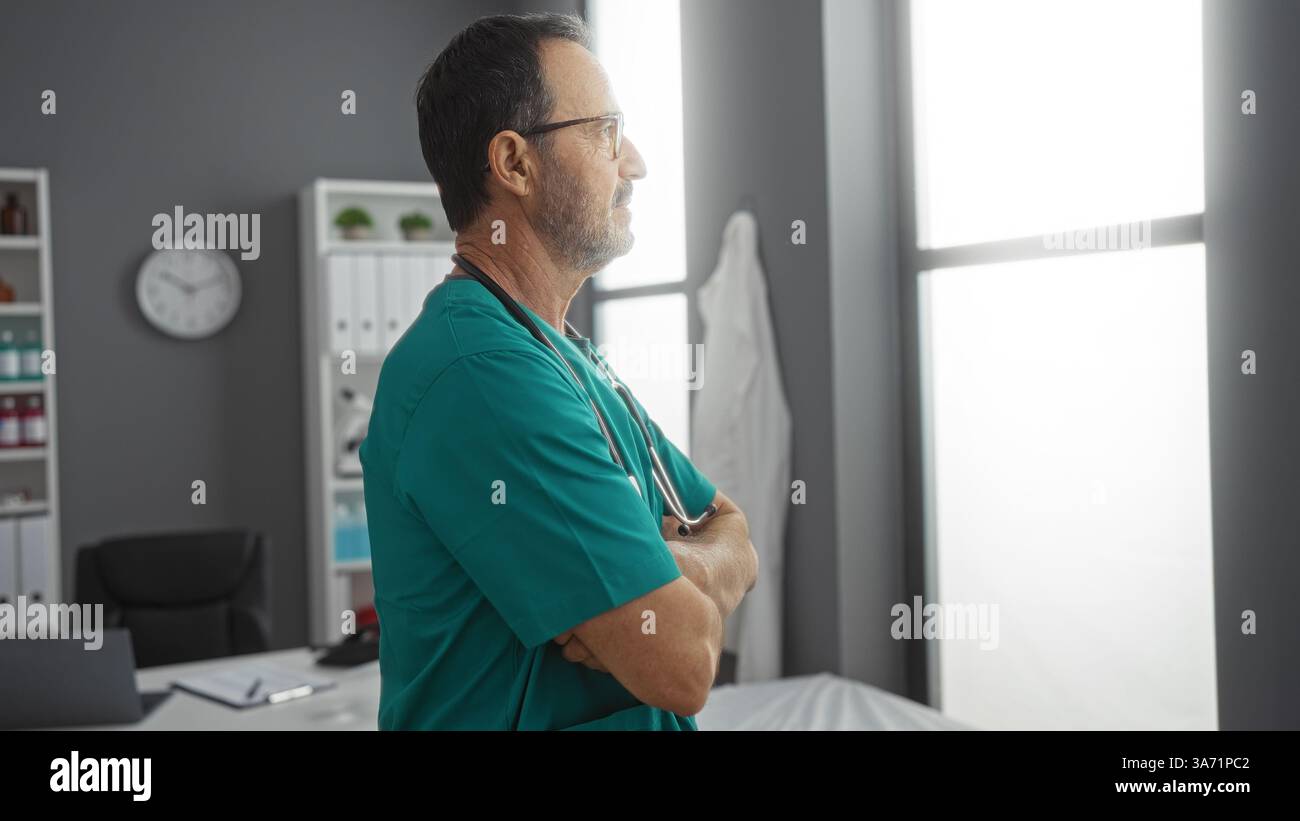 Hispanic man in medical scrubs stands with crossed arms gazing out ...