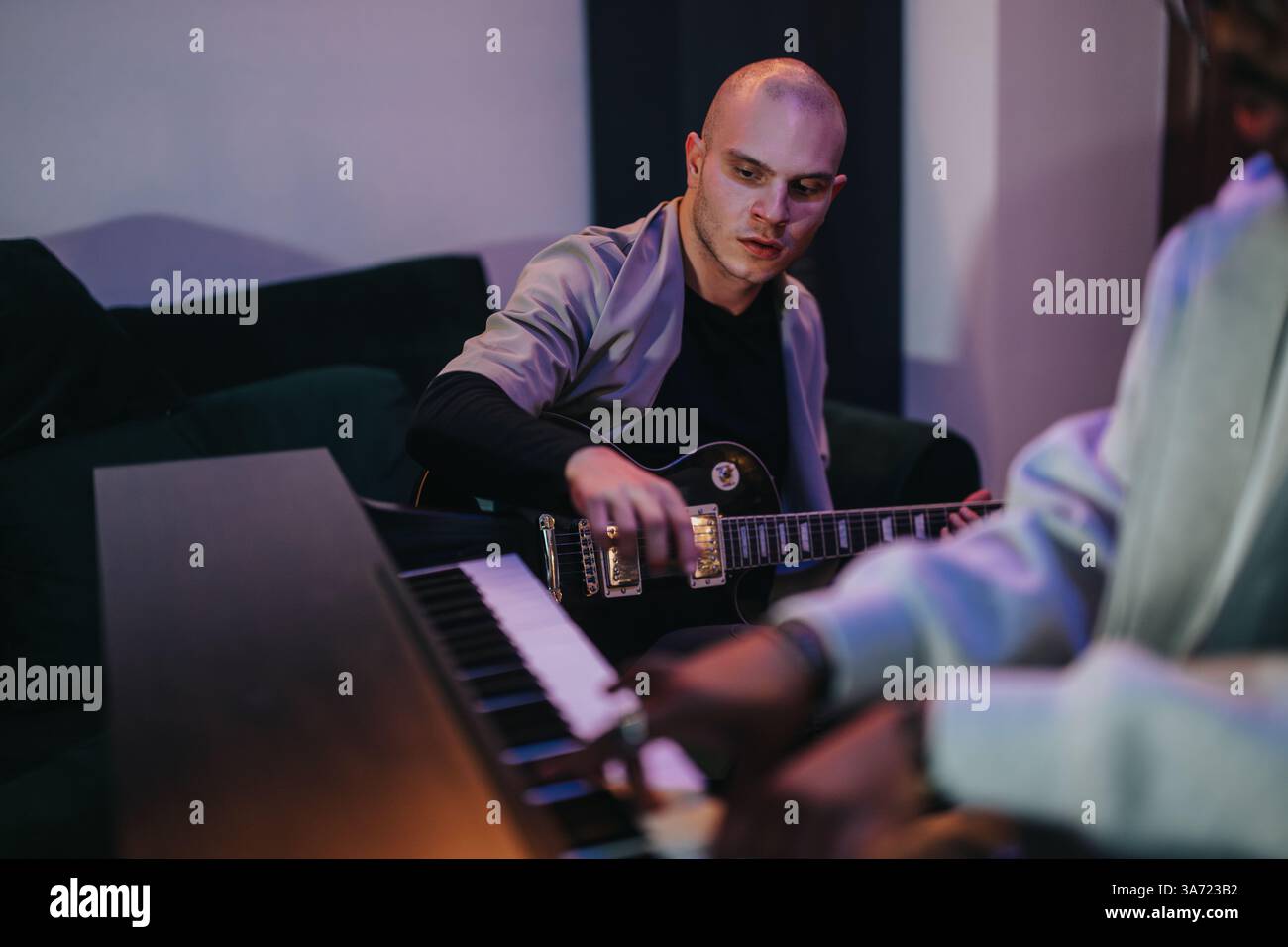 Musicians collaborating in a studio with guitar and piano instruments ...