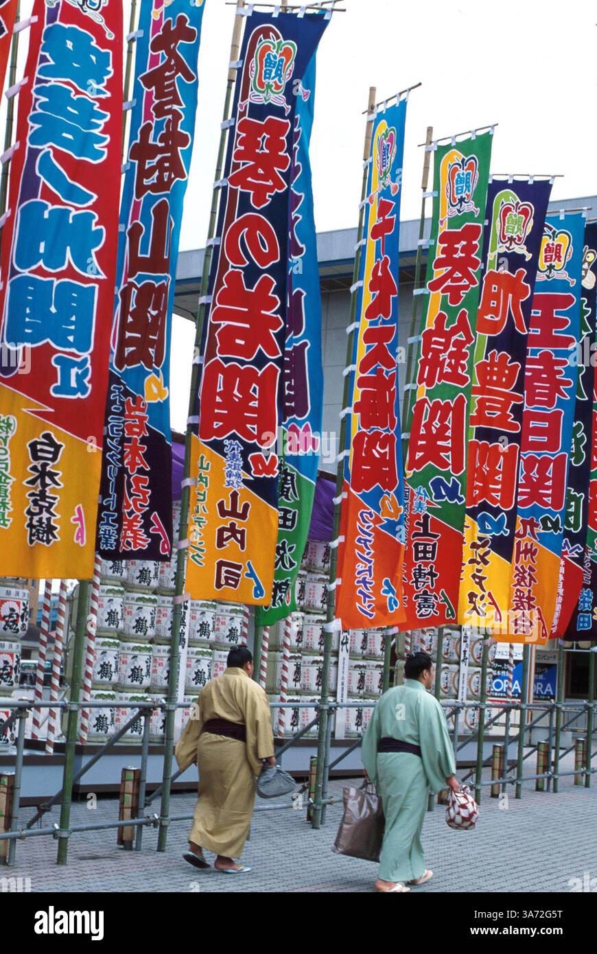 Jan. 1, 2011 - K32133 JAPAN.A COUPLE OF SUMO WRESTLERS PASS FLAGS WITH ...