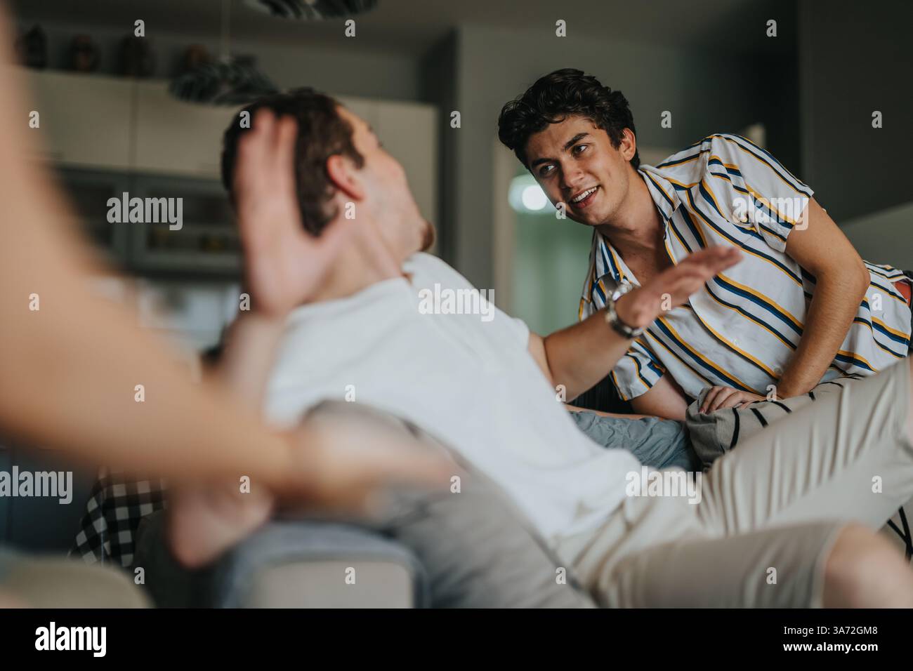 Two friends playfully interacting in a cozy living room Stock Photo - Alamy