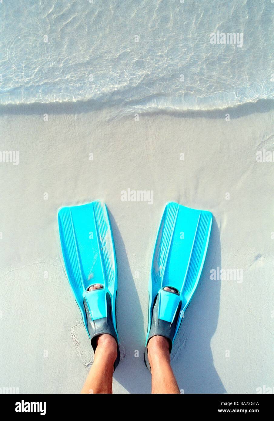 Mans legs with turquoise flippers on beach Stock Photo - Alamy