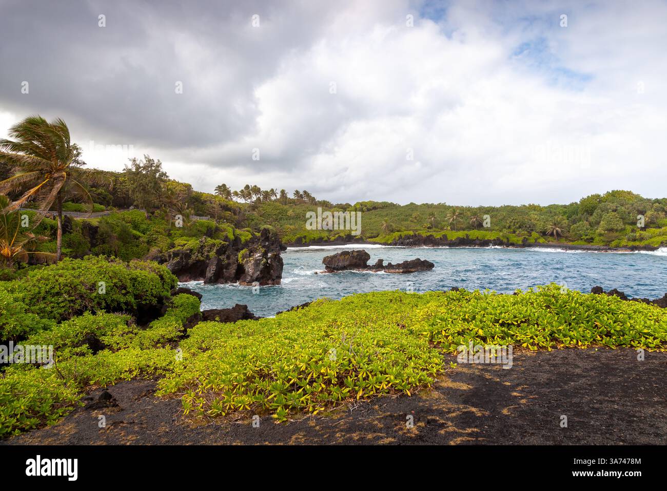 The stark contrast between deep blue ocean waves, volcanic rocks and ...