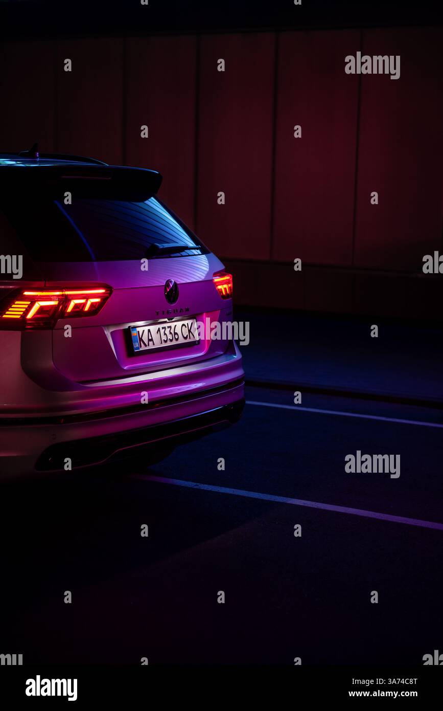 Purple Volkswagen Tiguan in parking lot an night. Rear end of modern ...