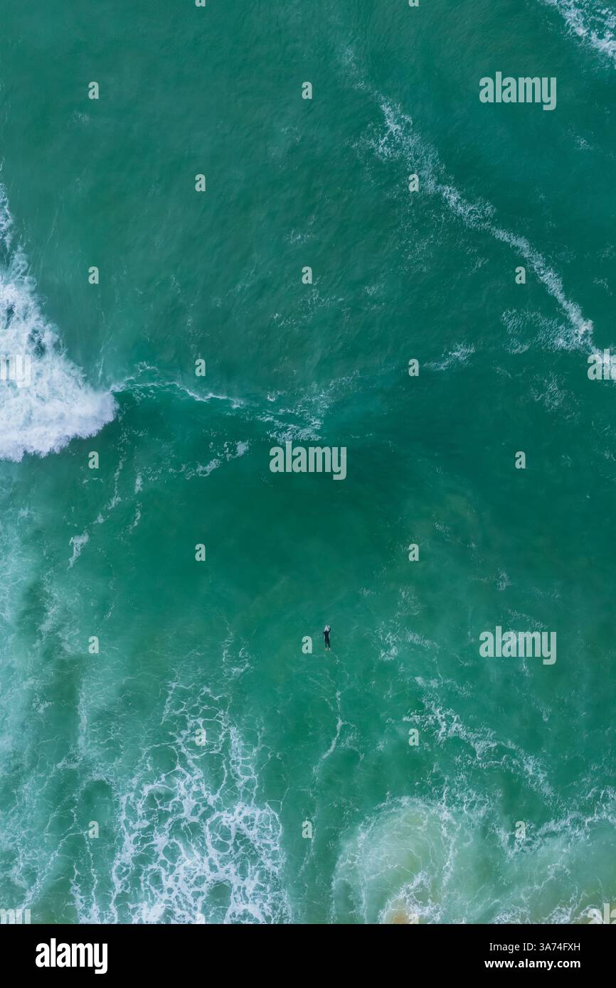 Aerial view of a surfer rowing in popular Supertubos beach, where the ...