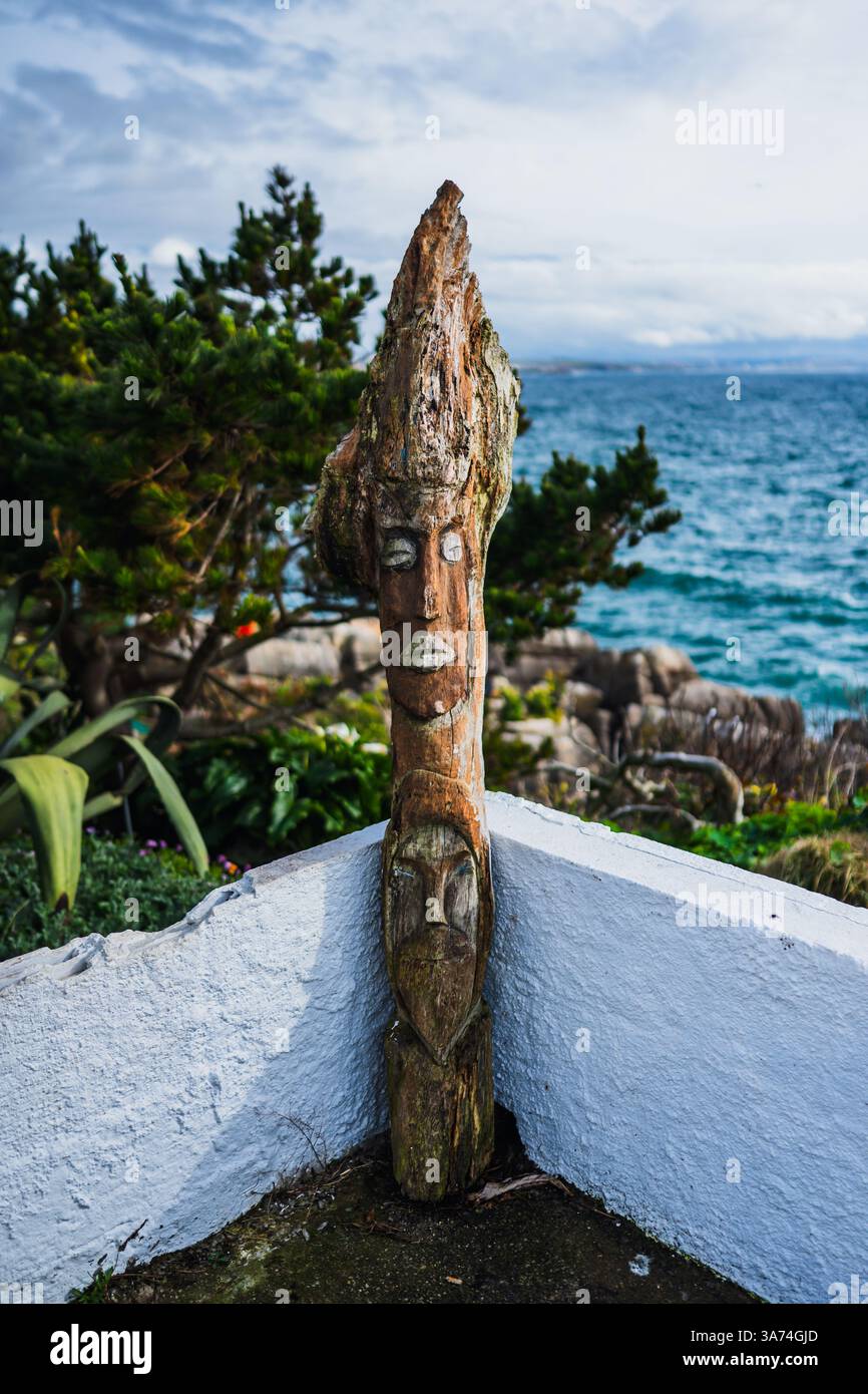 Face figures carved on wooden log, Peniche Stock Photo - Alamy