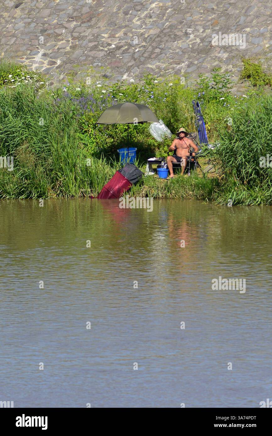 Man fishing while sunbathing on the river Mures Transylvania Stock ...