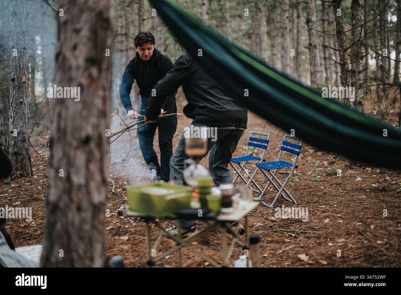 Two People Preparing a Campfire in a Forest While Camping Outdoors ...