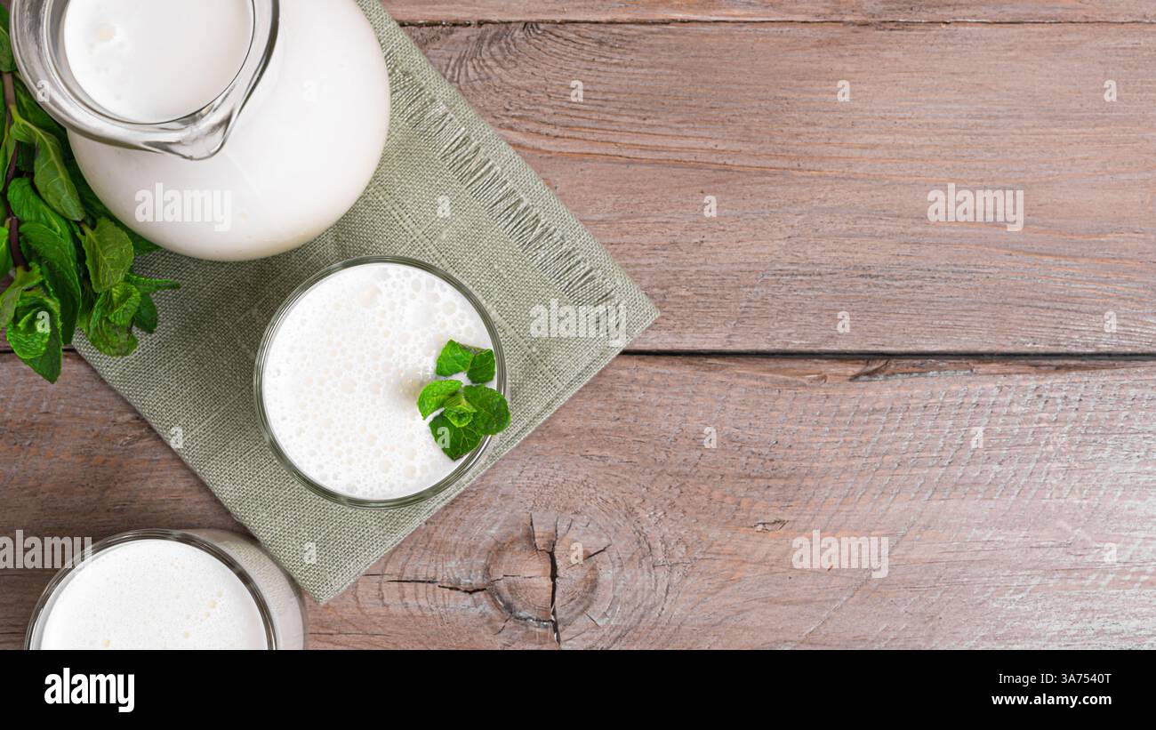 Fresh plain homemade yogurt, kefir, ayran, lassi in glasses and jug on ...