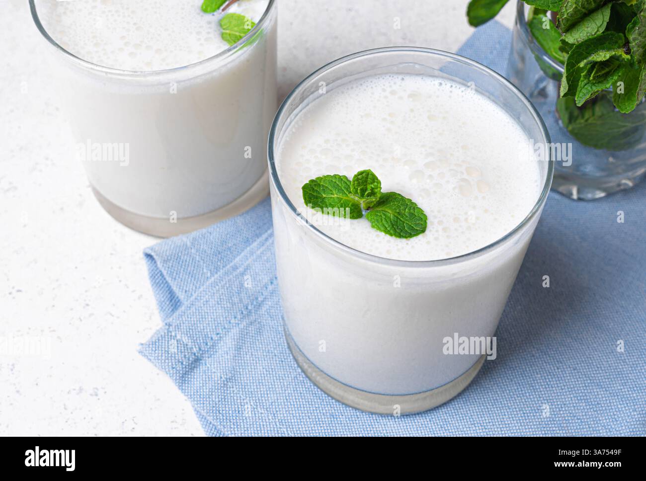 Fresh plain homemade yogurt, kefir, ayran, lassi in glasses with mint ...