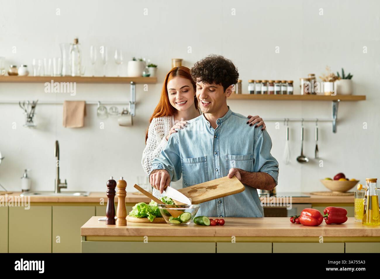 A young couple makes joyful memories together while cooking at home ...