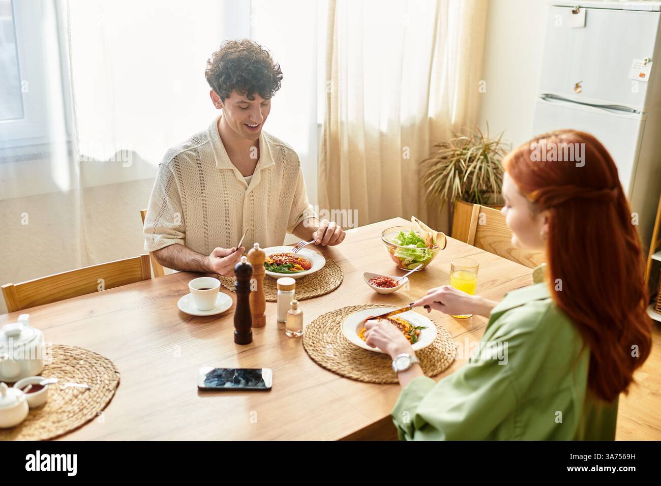 Joyful couple enjoys a cozy meal, sharing laughter and connection in ...