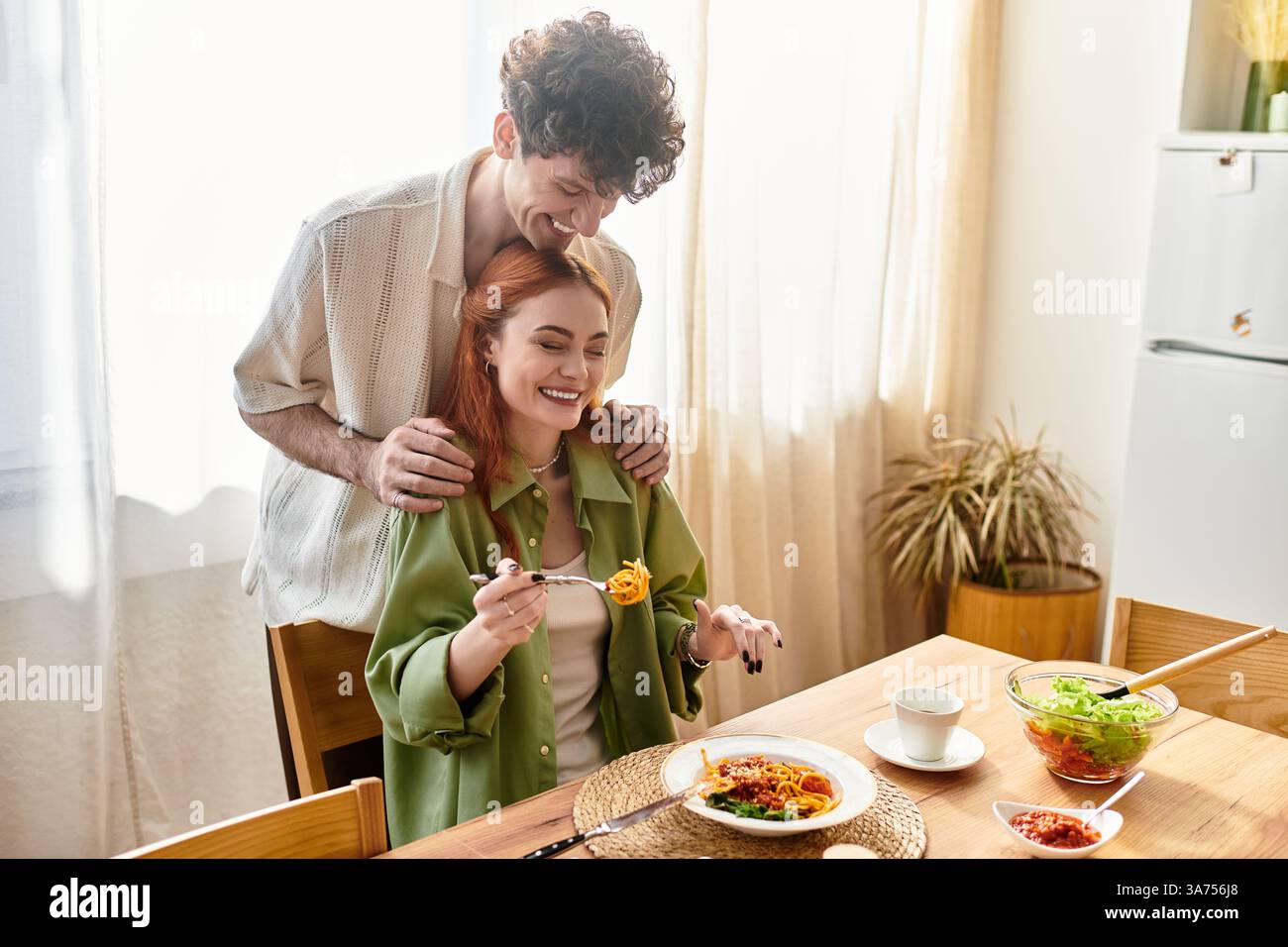 A young couple shares a warm meal, enjoying joy and connection in their ...