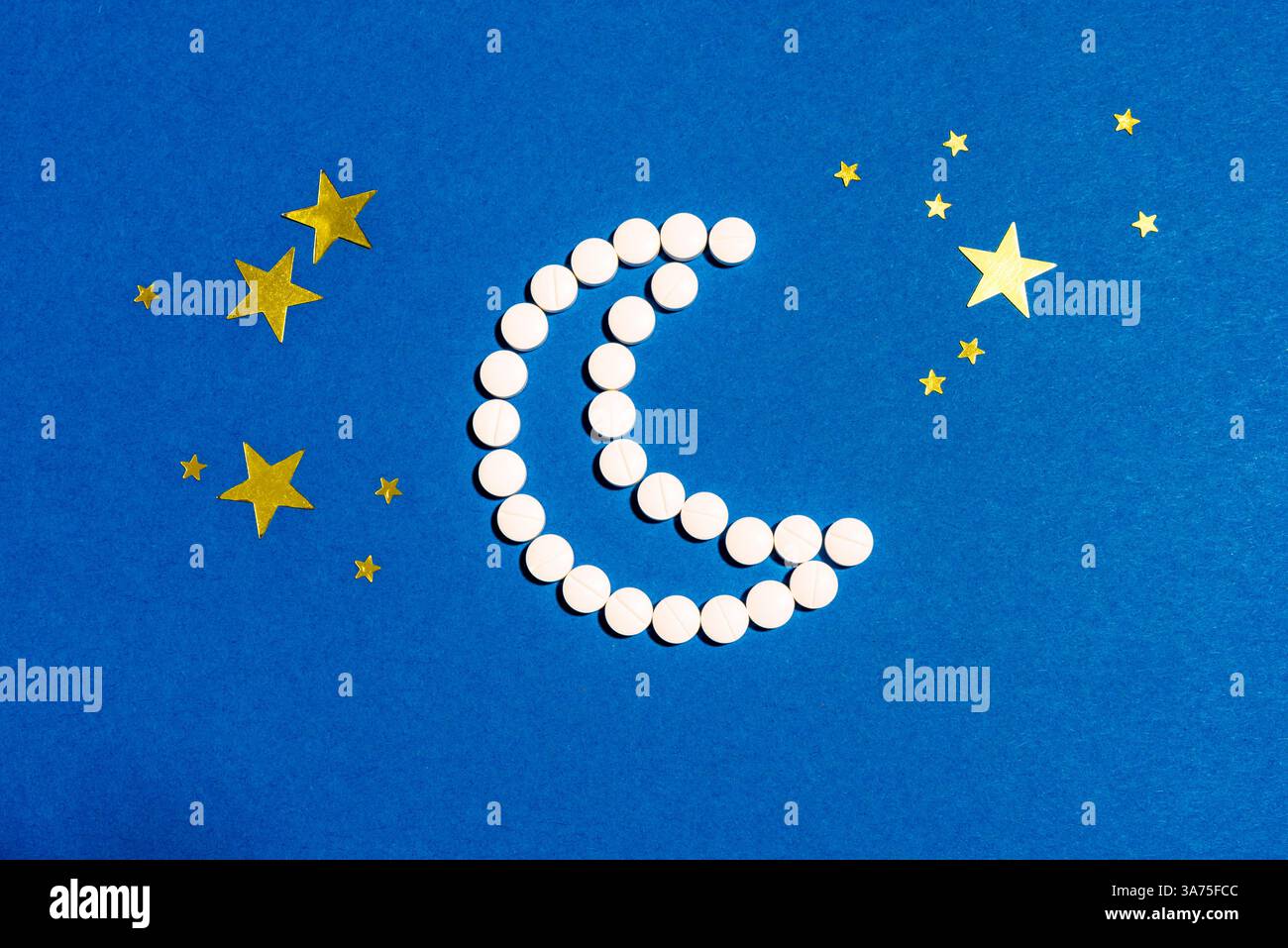 Melatonin tablets in shape of crescent moon on dark blue background ...