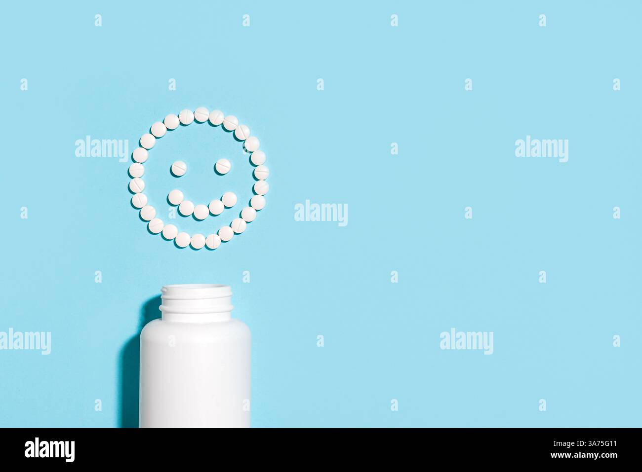 Happy smiling face made of white pills and blank container on blue ...