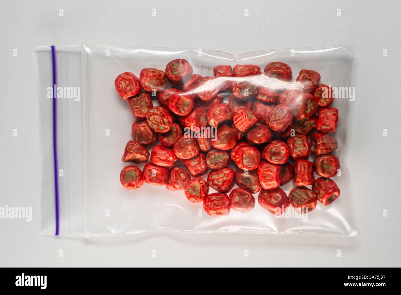 Red pea seeds in transparent plastic packaging close-up on a white ...