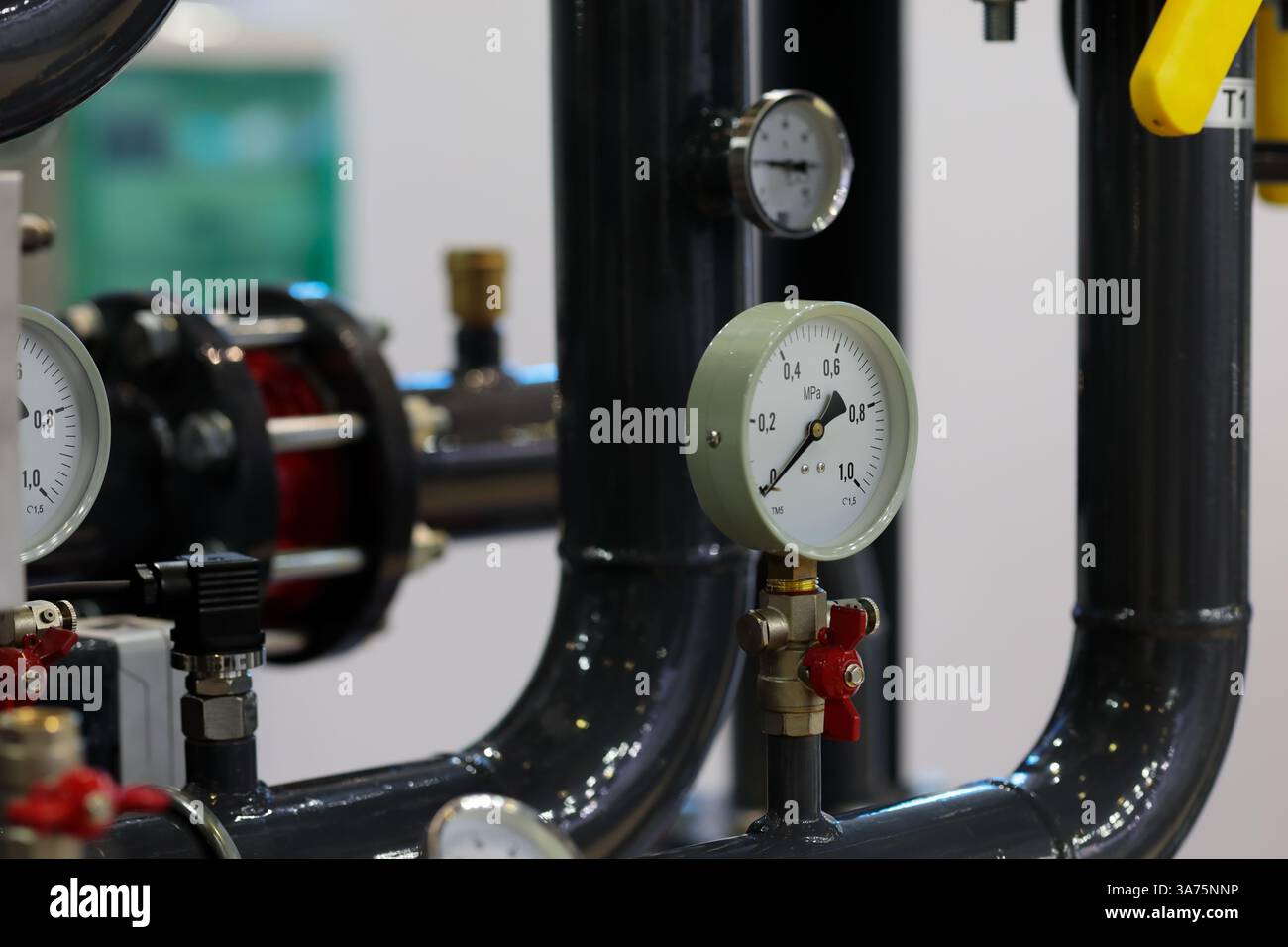 Closeup of industrial process piping system with pressure gauges and ...