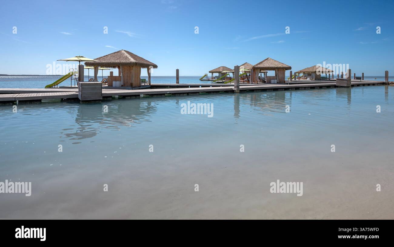 Thatched roof Palapas and elevated walkway in the Caribbean Sea at the ...