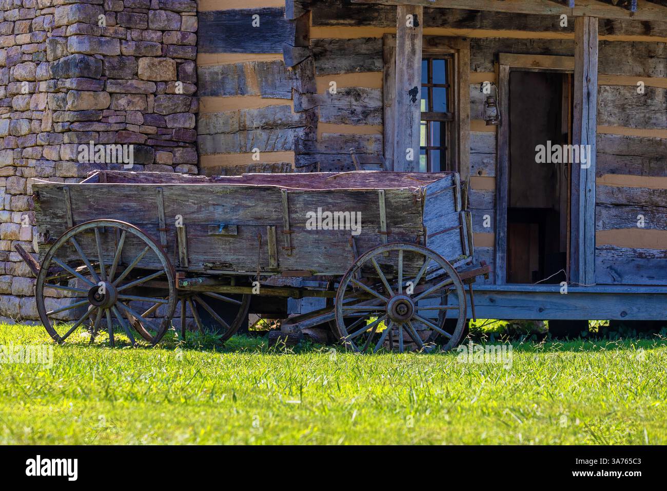An old wooden wagon sits outside of an old log cabin in rural Tennessee ...