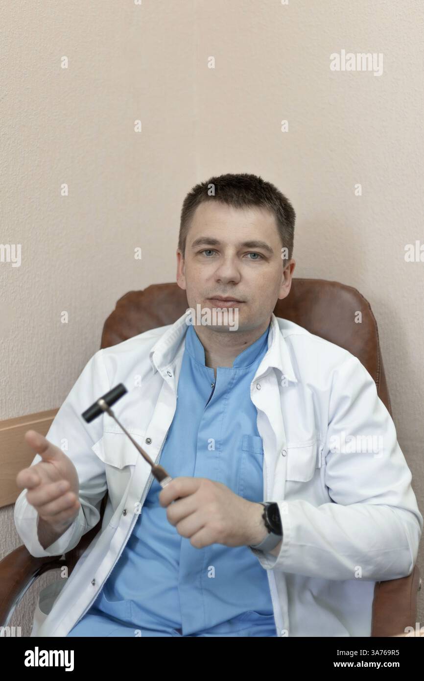 Male doctor holding a reflex nerve tapping instrument in his hand Stock ...