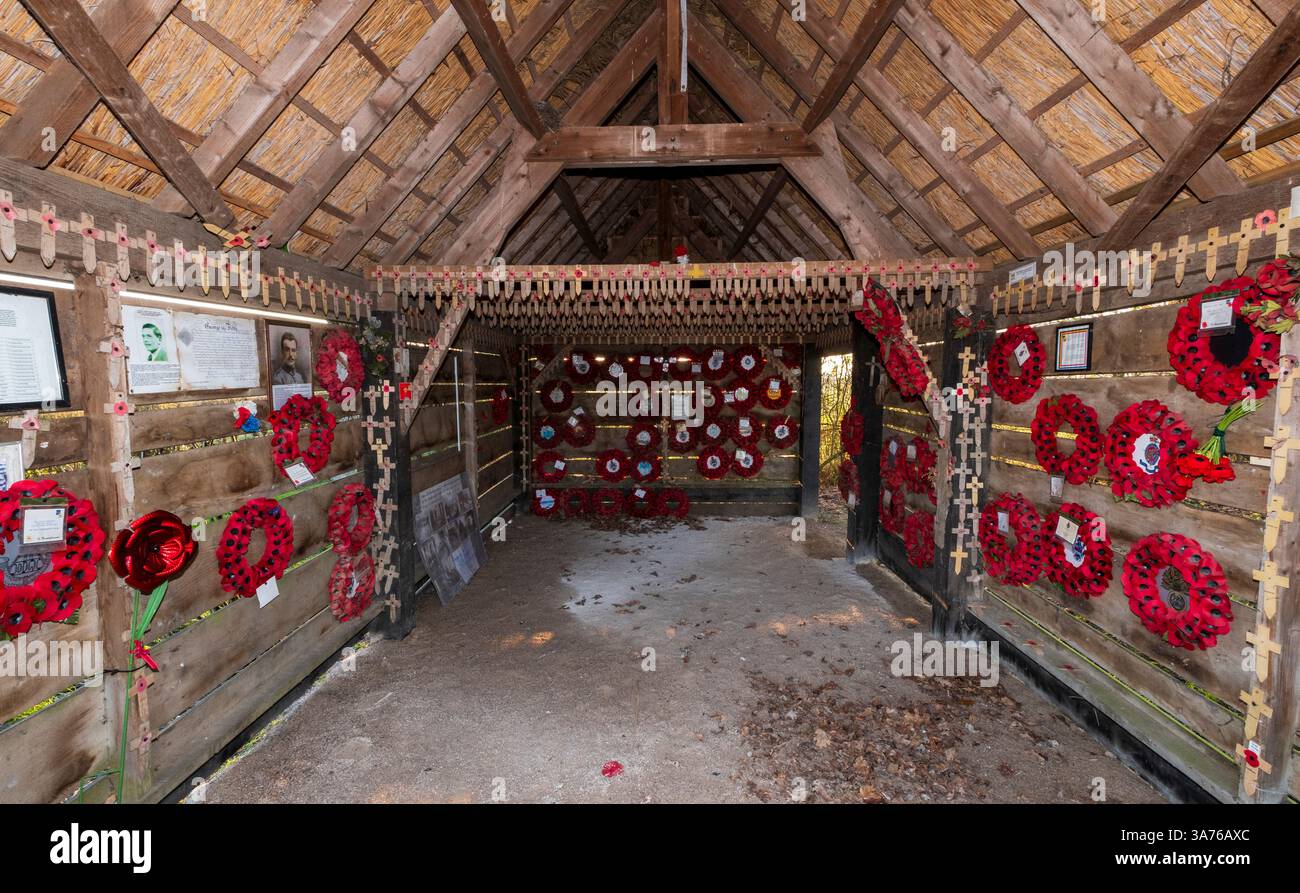 Inside a rustic wooden structure, a memorial space is adorned with red ...