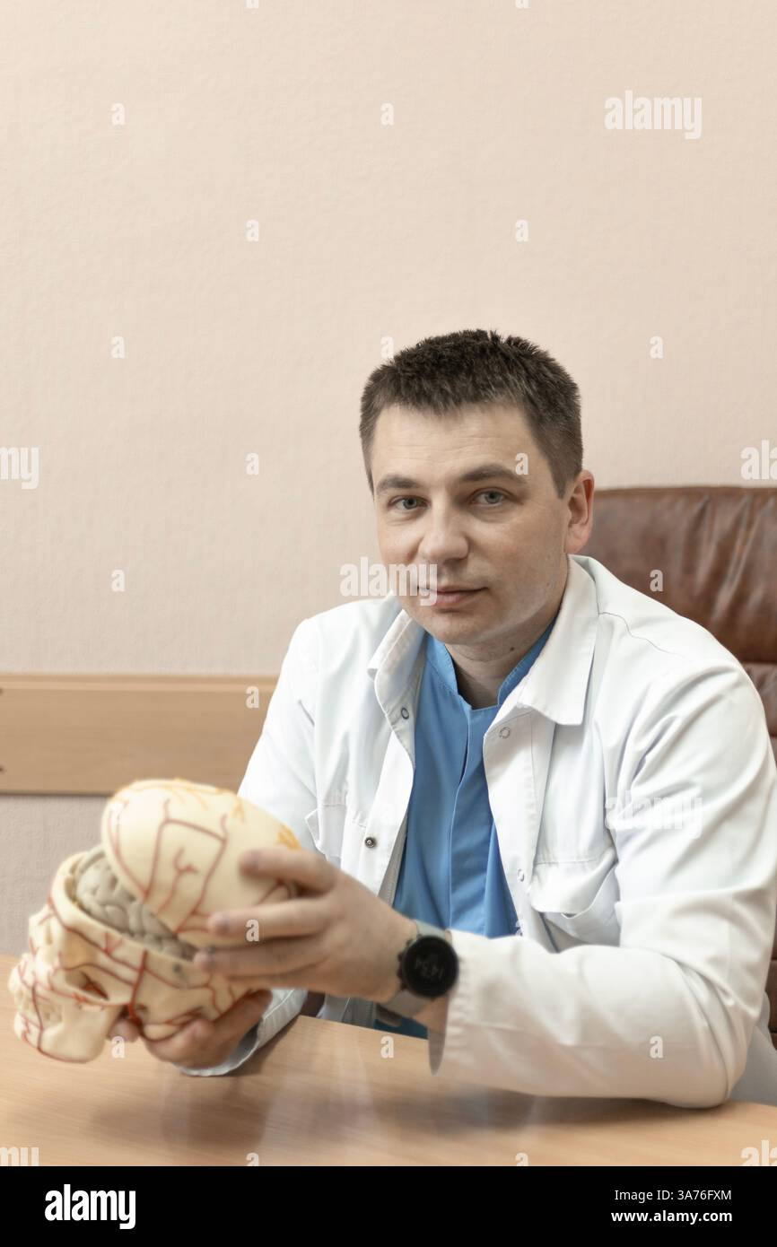 male doctor holding a model of a human skull with an open cranium Stock ...