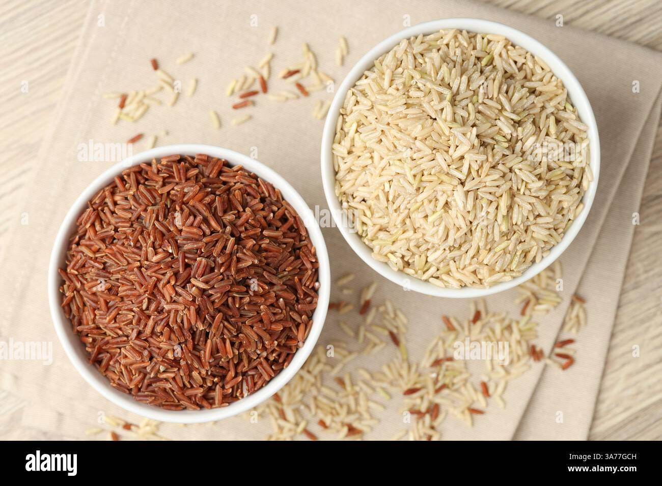 Different types of brown rice in bowls on wooden table, flat lay Stock ...