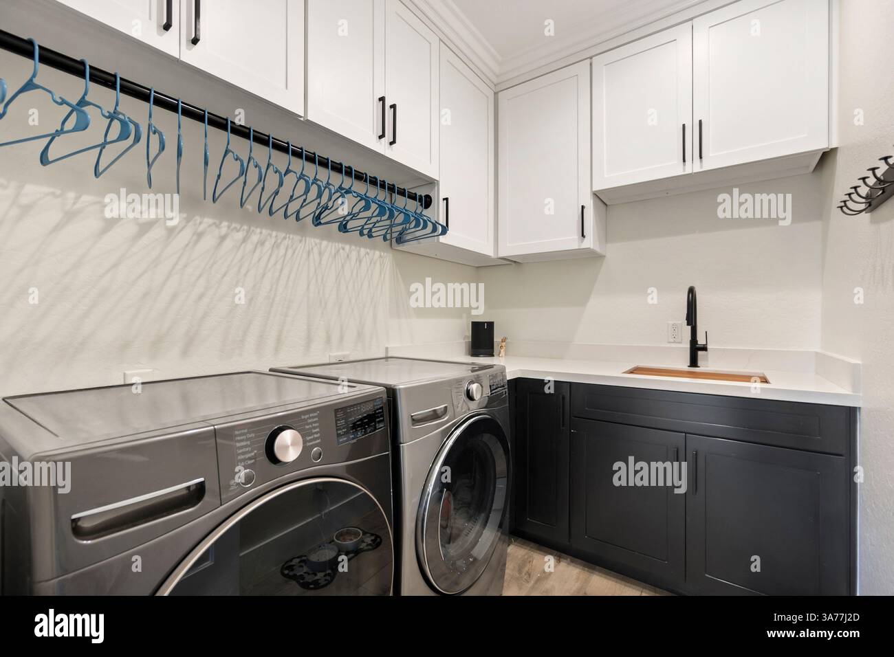 A laundry room that features both a washer and dryer and a sink Stock ...