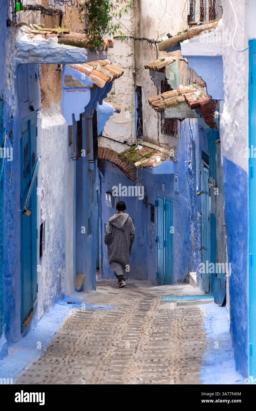 Man wearing jaballa in the blue and white painted old town Medina in ...