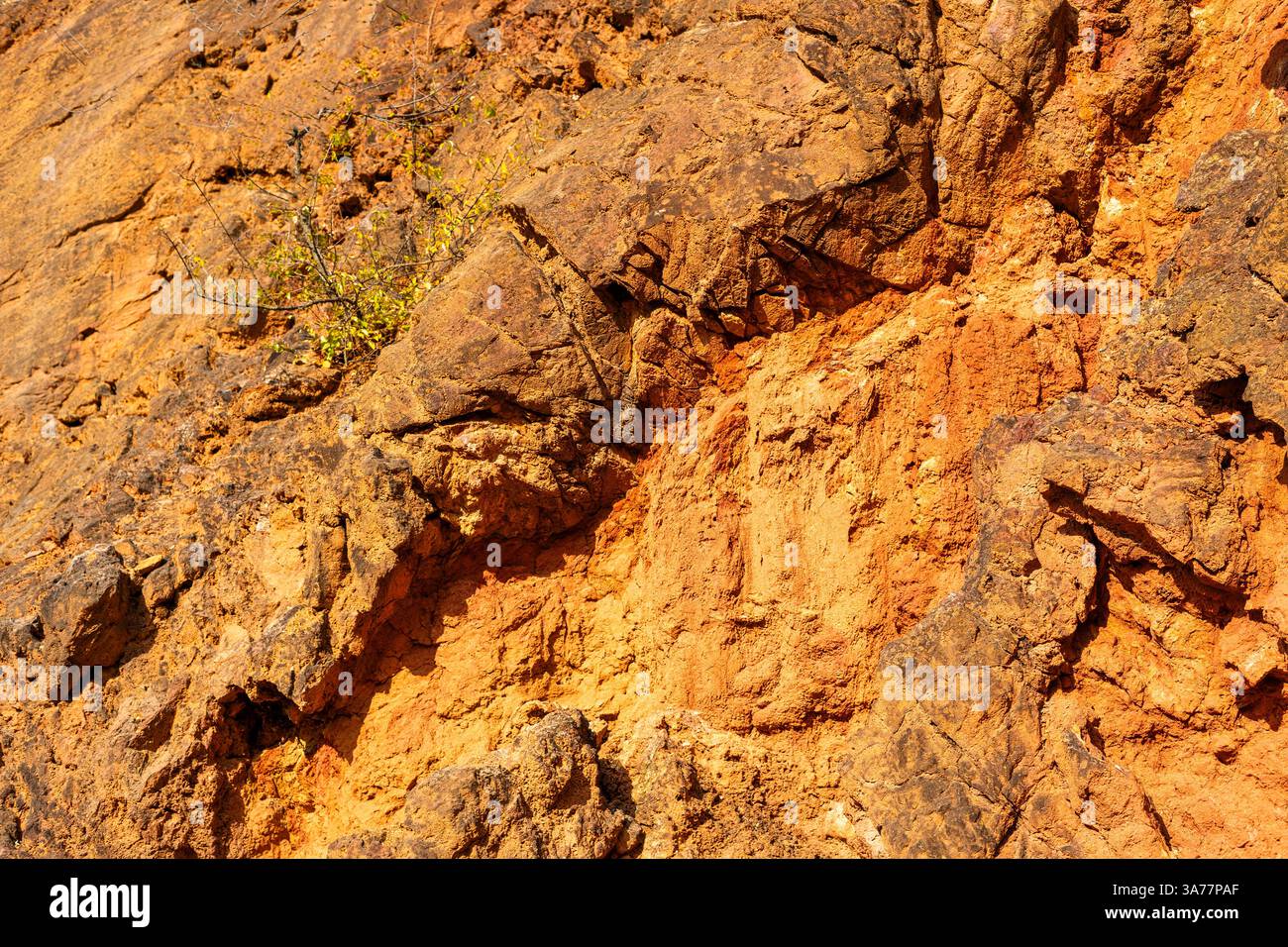 Eroded bauxite rock formation with bright orange colors in an abandoned ...