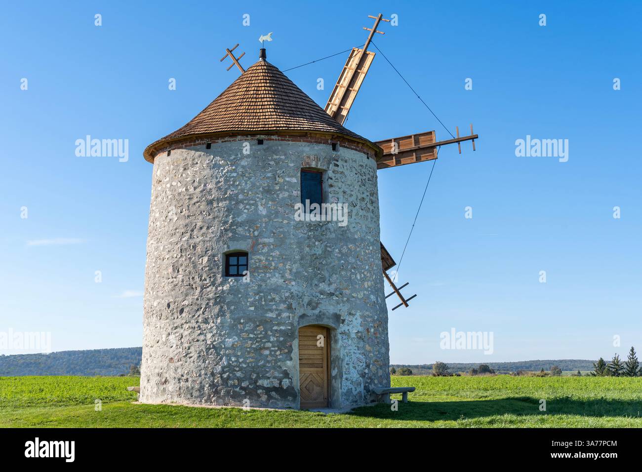 Rustic stone windmill in a grassy field Stock Photo - Alamy