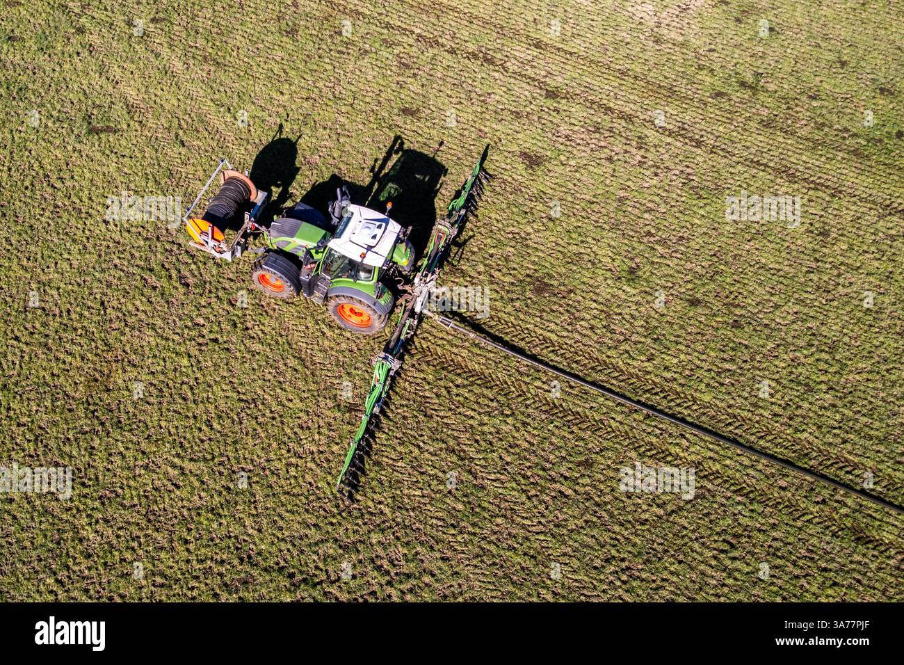 Farmer spreads slurry using an umbilical pump system and dribble bar ...