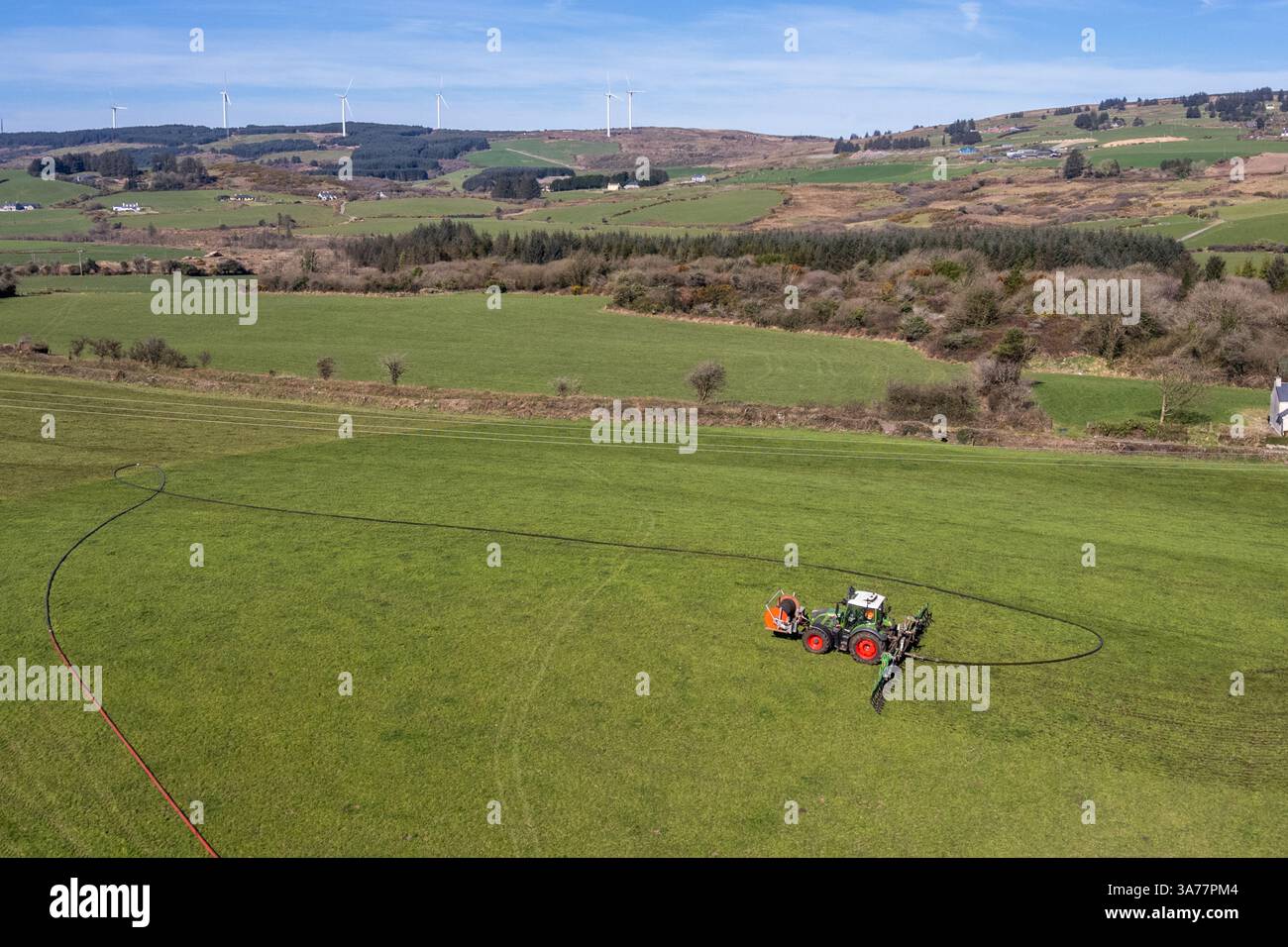 Farmer spreads slurry using an umbilical pump system and dribble bar ...