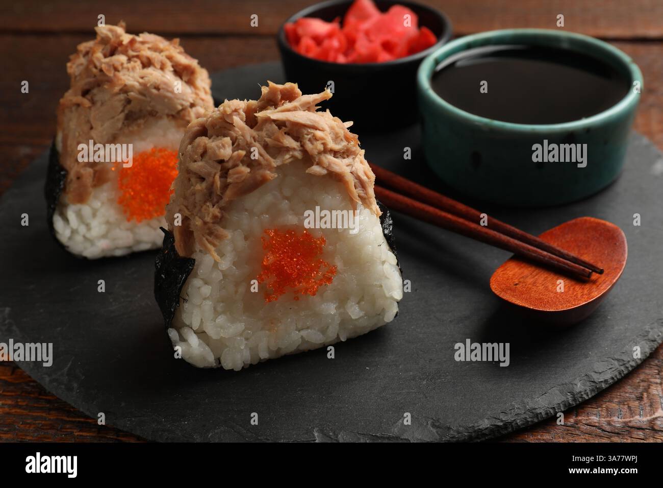 Tasty onigiri (Japanese rice balls) with tuna served on wooden table ...