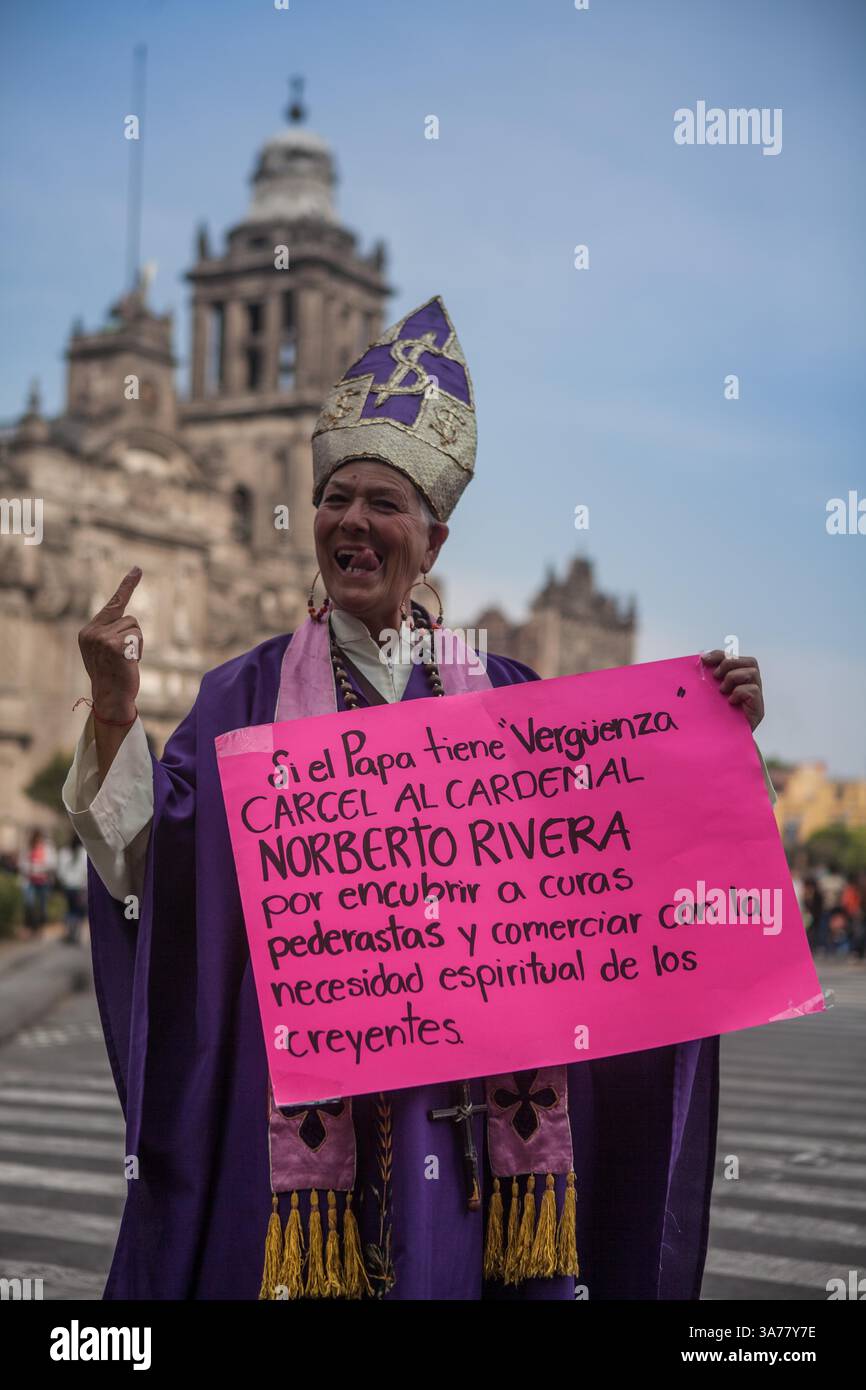 Woman dressed as Pope, making a finger sign and holding a pink ...