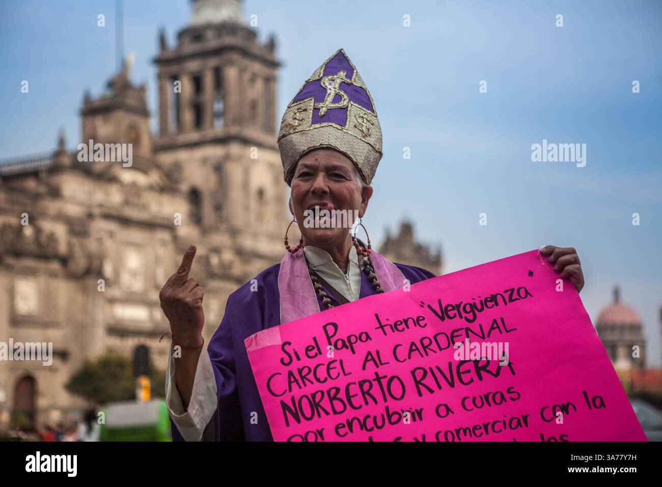 Woman dressed as Pope, making a finger sign and holding a pink ...