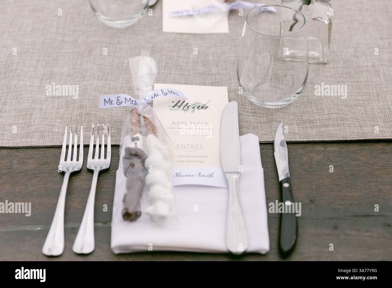 Decorative table features utensils, place cards, and a menu for guests ...