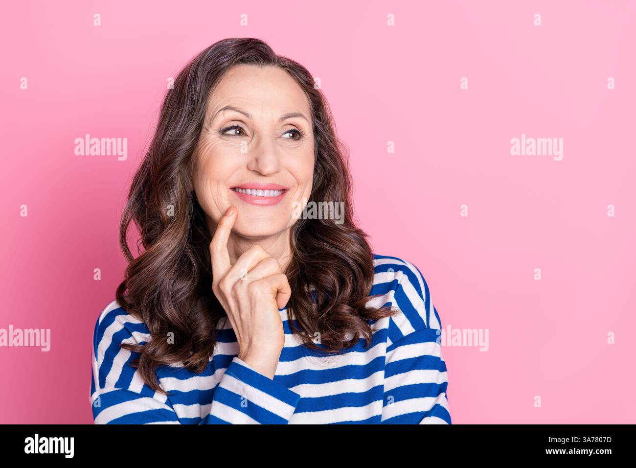 Portrait of a smiling mature woman in a striped shirt posing ...