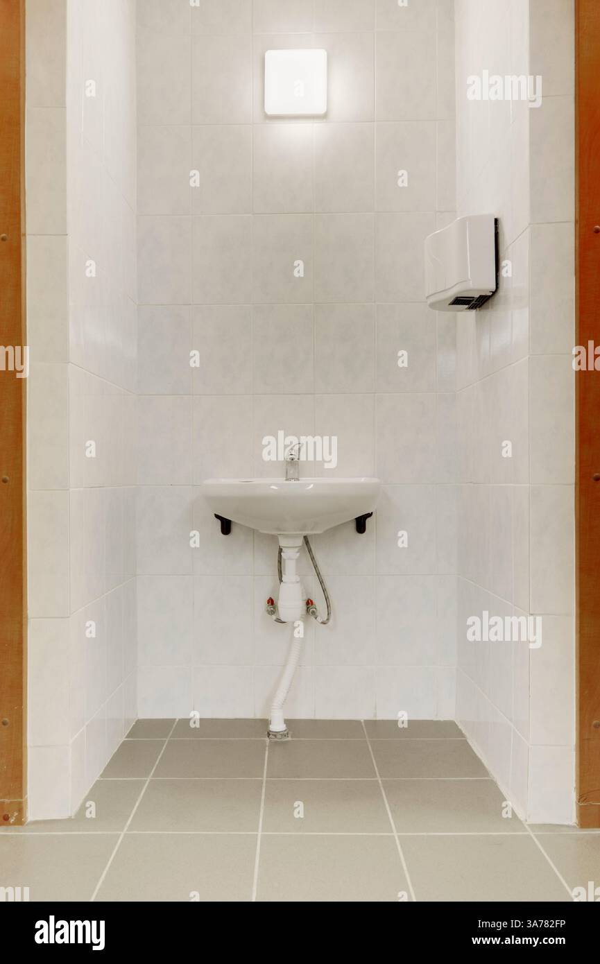 Basin and hot air hand dryer in the changing rooms of a sporting venue ...