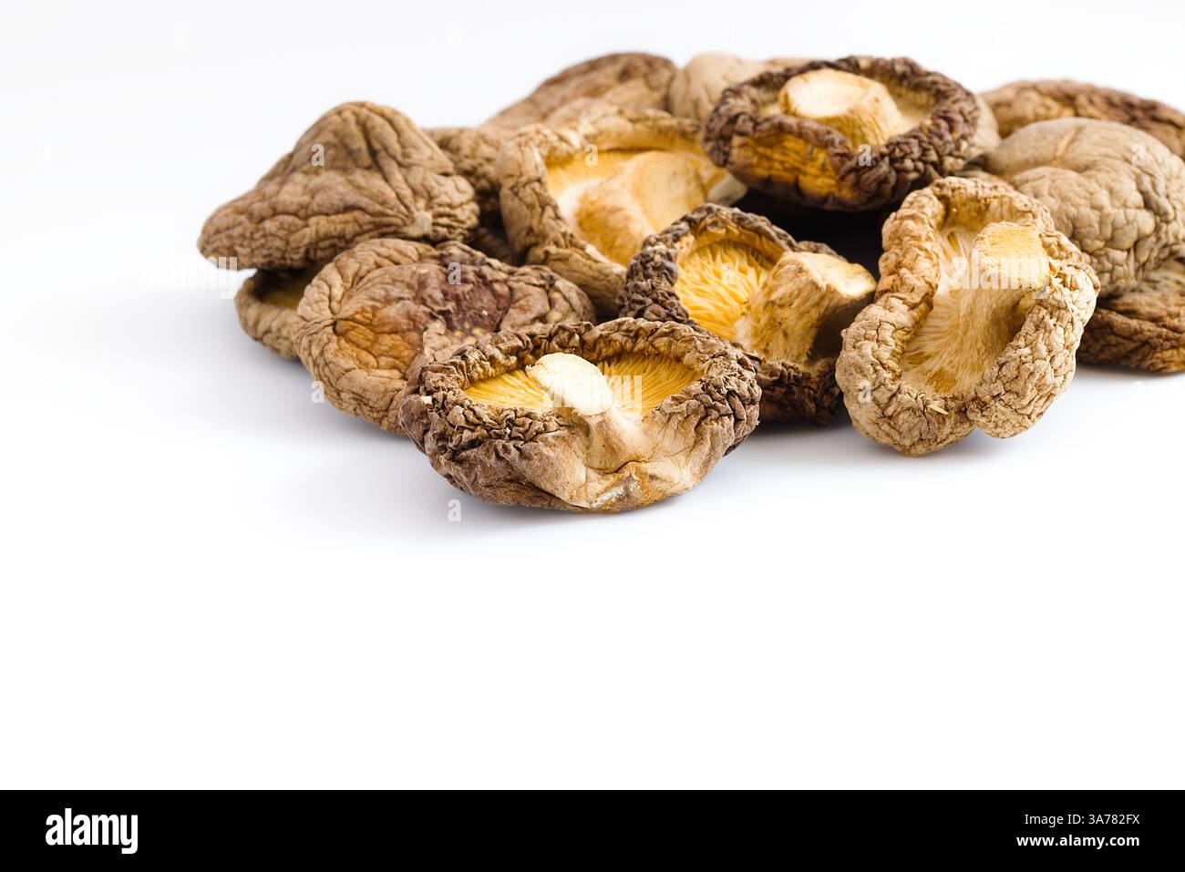 Displayed on a crisp white surface, dried shiitake mushrooms reveal ...
