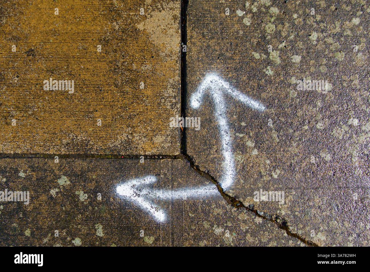 Spray painted arrows on broken pavement Stock Photo - Alamy
