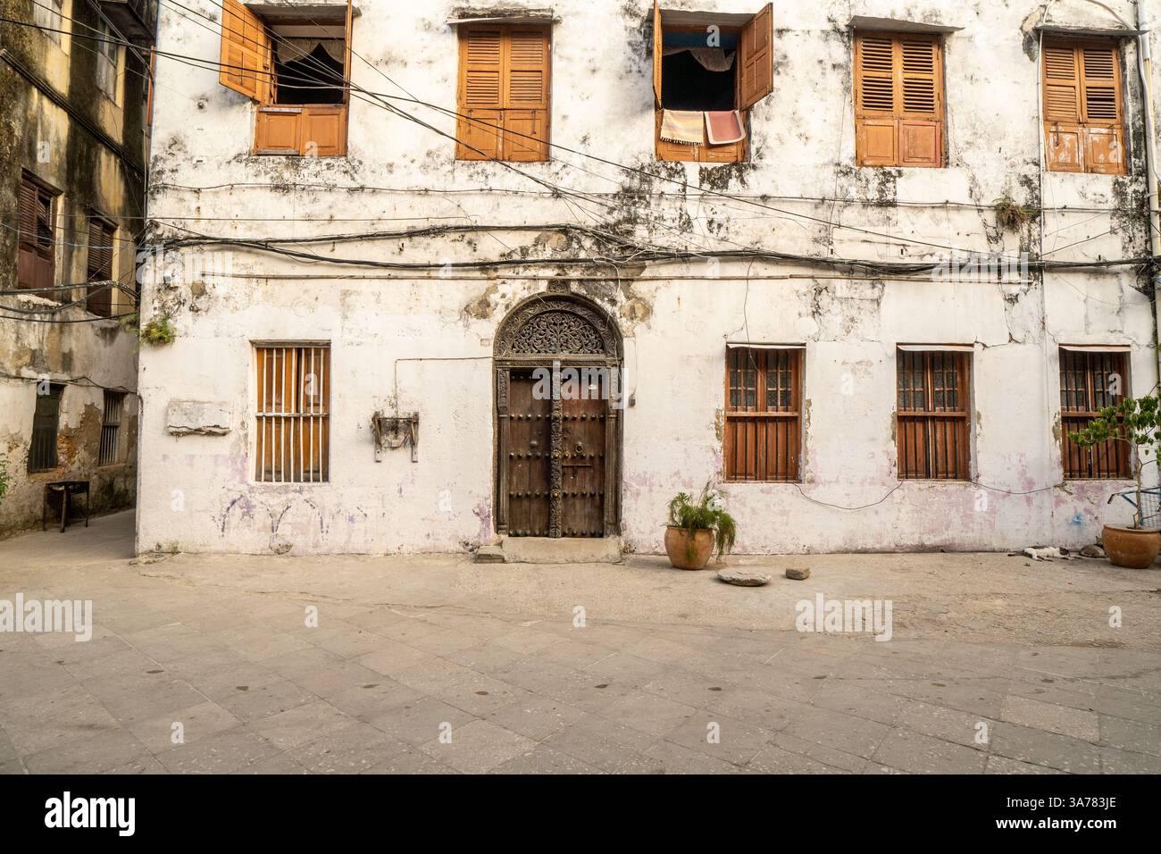 An old Zanzibari building with weathered walls and open windows at ...
