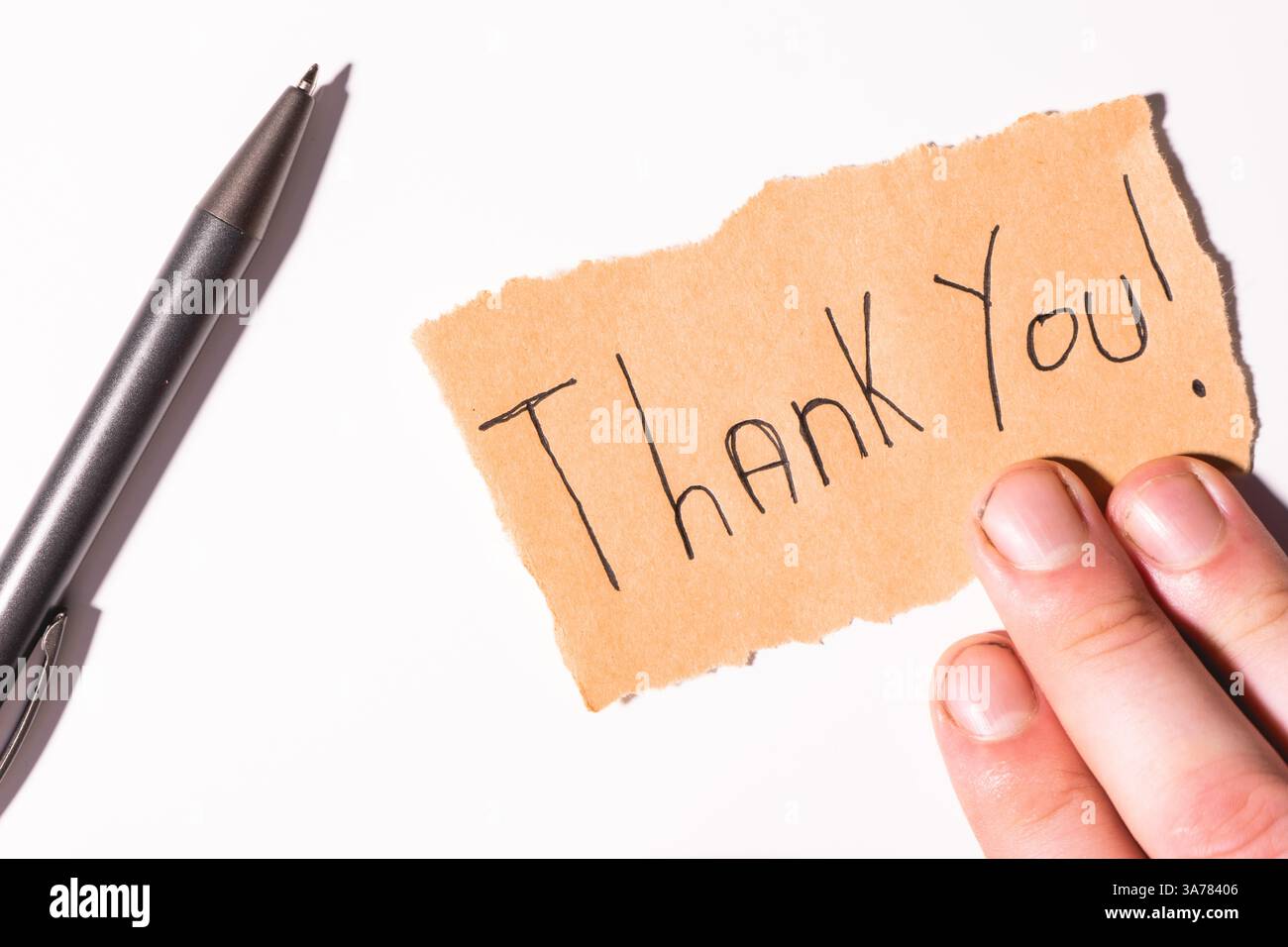 A handwriting Thank you note on brown paper, on a white background ...