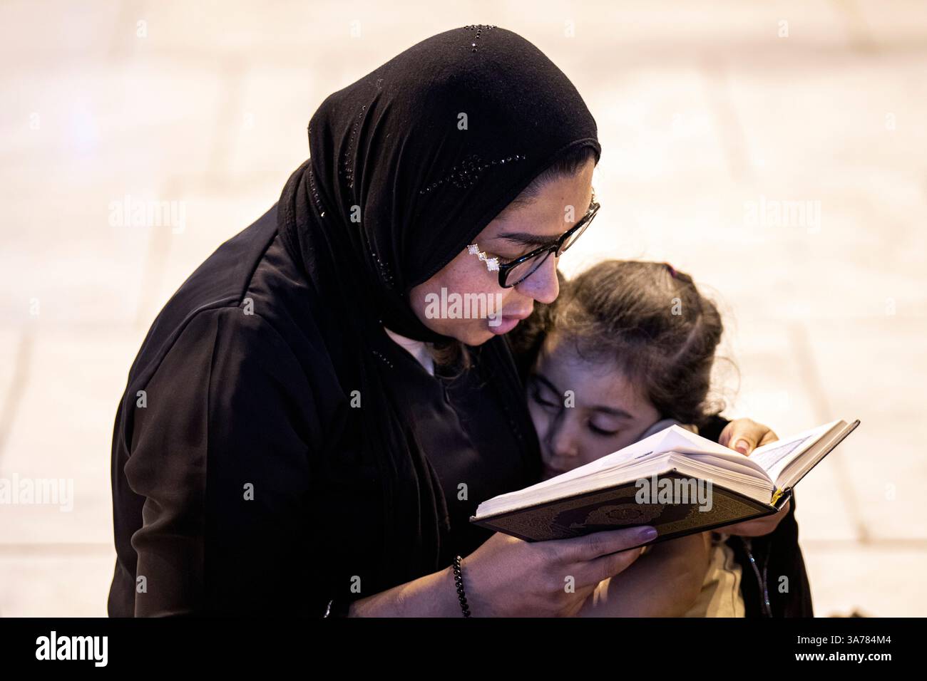 A Sunni woman reads the Quran during Laylat al-Qadr, or the Night of ...