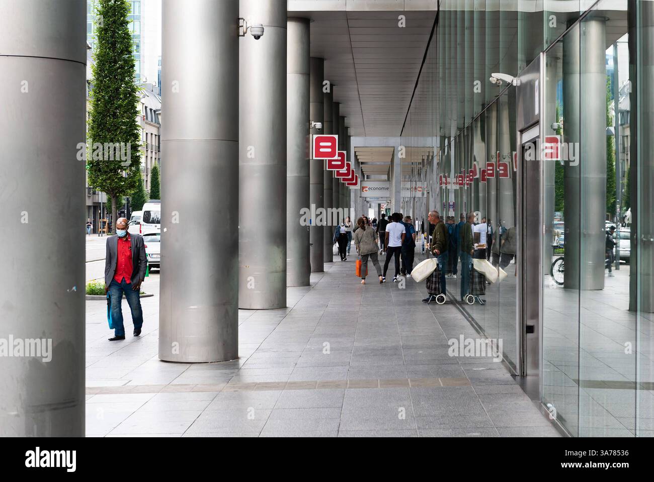 Column covered hall at the Belfius tower with pedestrians and the ...