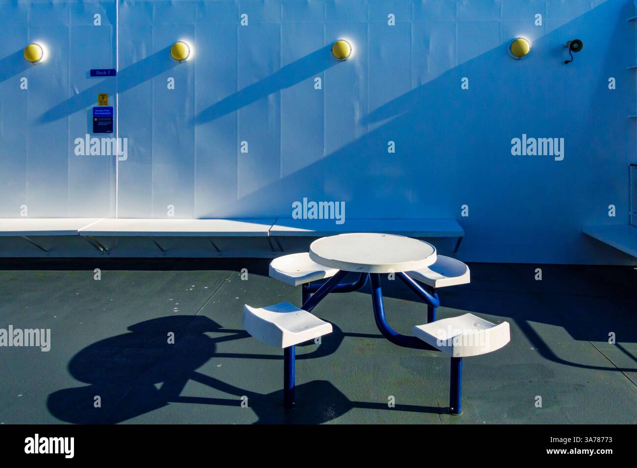 A ferry deck, fixed seating and a round table Stock Photo - Alamy