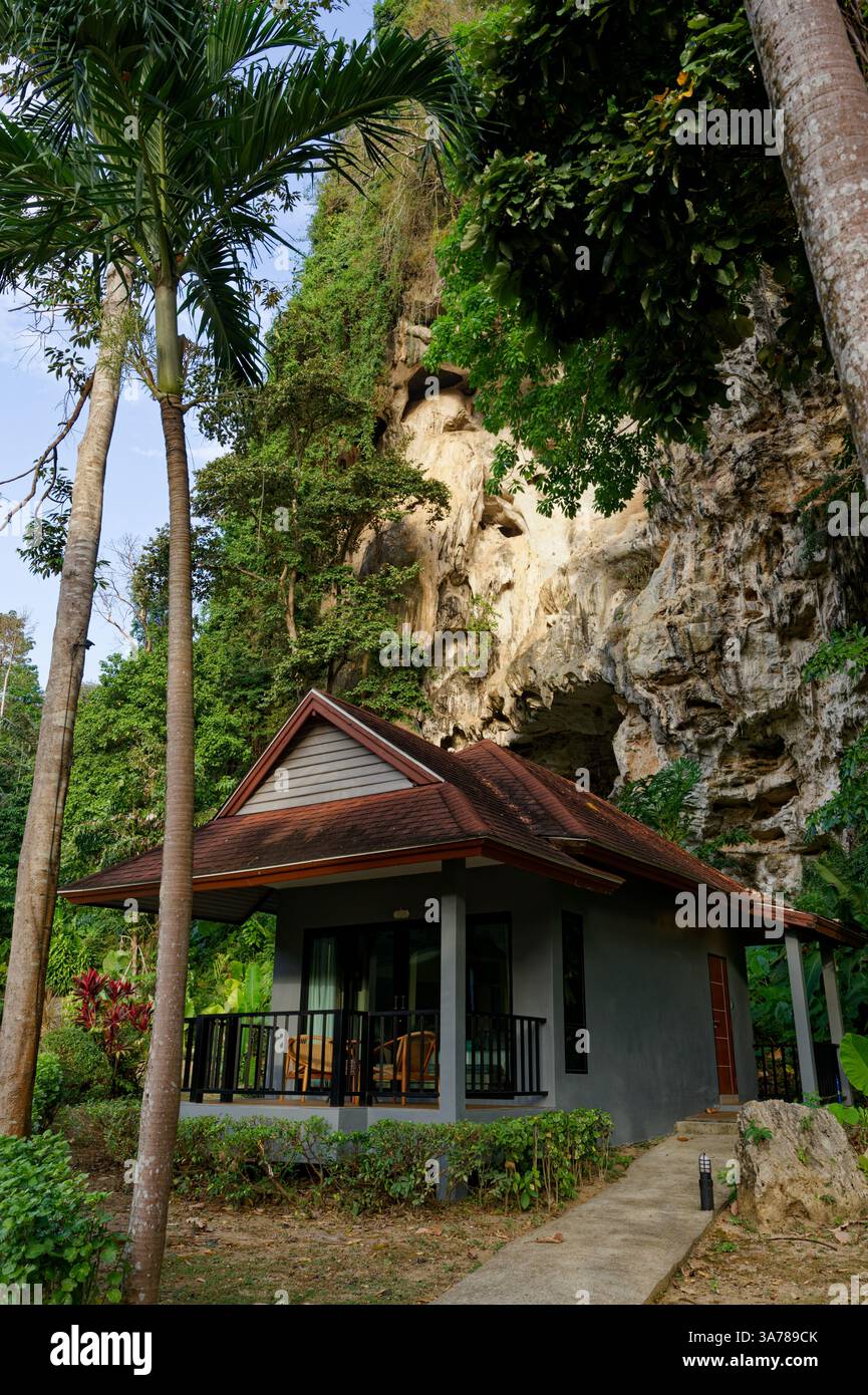 Cozy tropical bungalow nestled beneath limestone cliffs in the lush ...