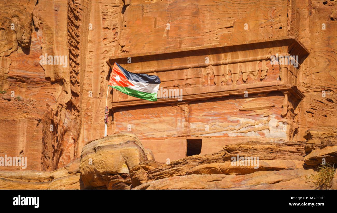 view of Jordan flag stuck in a rock in Petra, Siq gorge, Wadi Musa ...