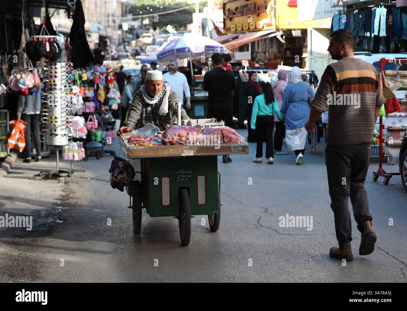 Nablus. 26th Mar, 2025. People visit a market ahead of the Eid al-Fitr ...