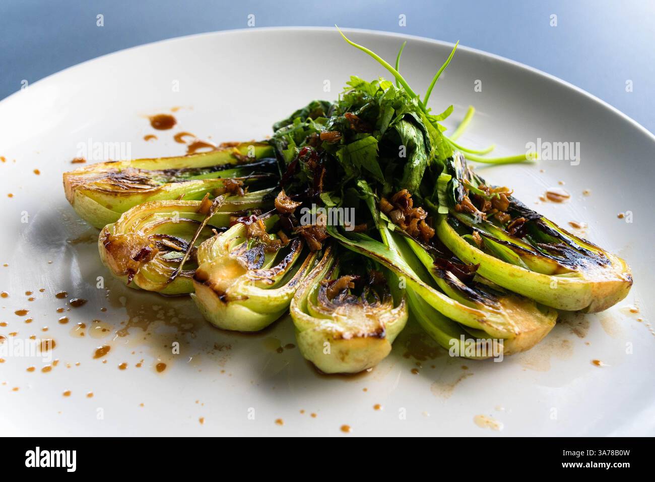 Grilled bok choy showcases vibrant green colors, topped with fresh ...