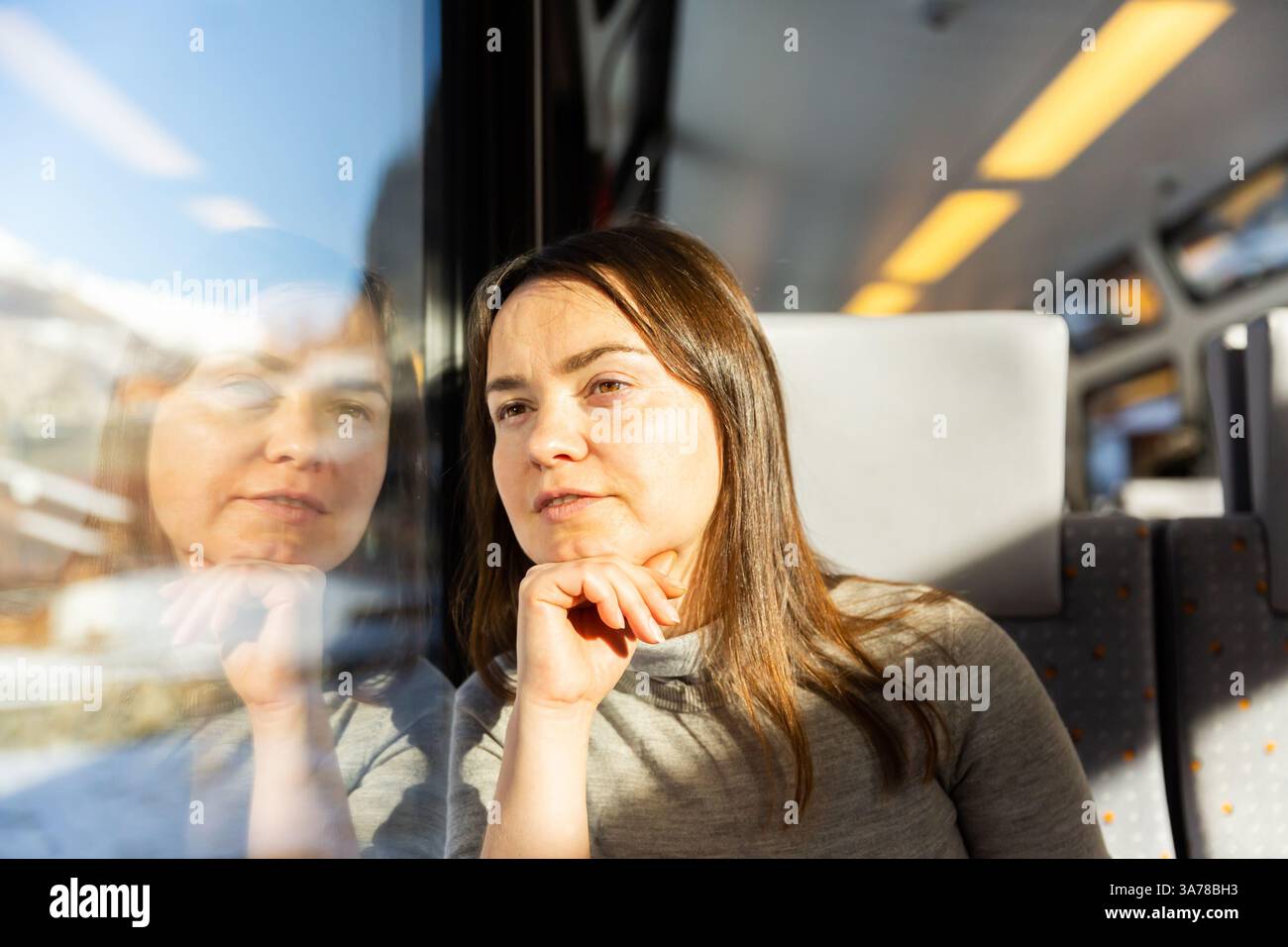 Reflective woman looking through train window while journeying Stock ...